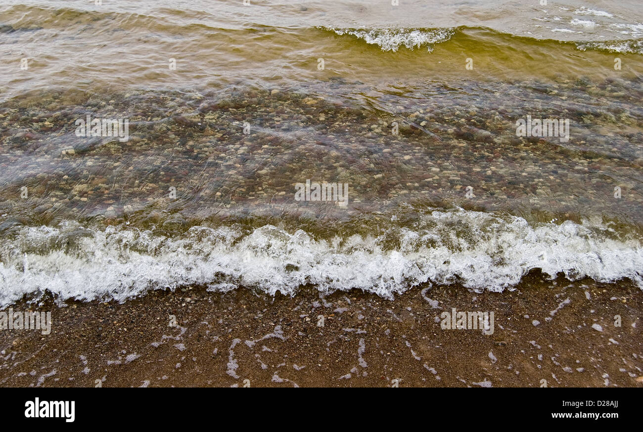 Running wave. The wave runs on sandy coast Stock Photo - Alamy