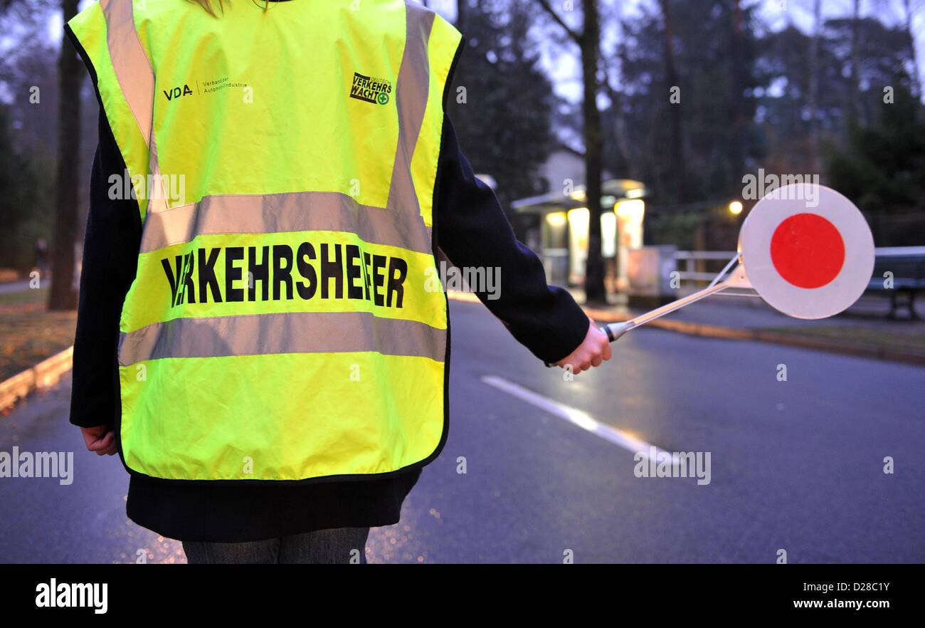 School crossing guard holds a signalling disc in her hand indicating ...
