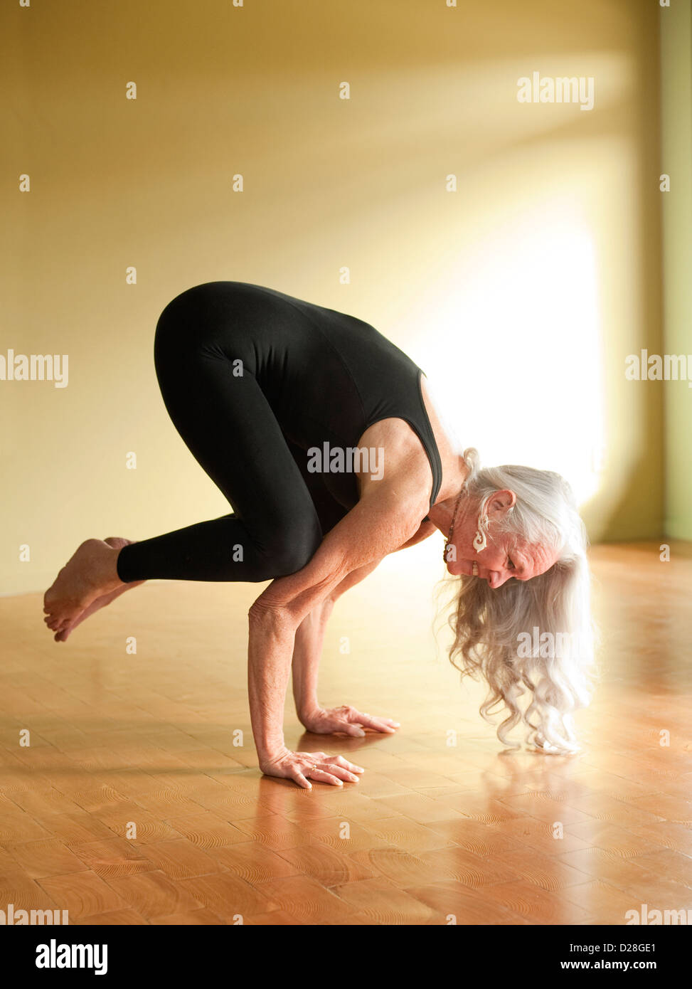 Mature woman in the yoga posture Bakasana or crow pose Stock Photo - Alamy
