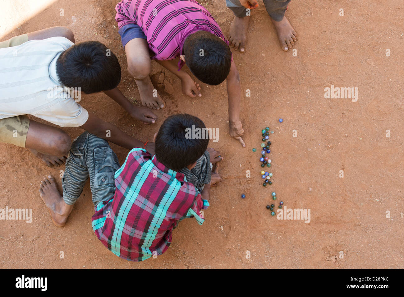 Boys playing game marbles in hi-res stock photography and images - Alamy