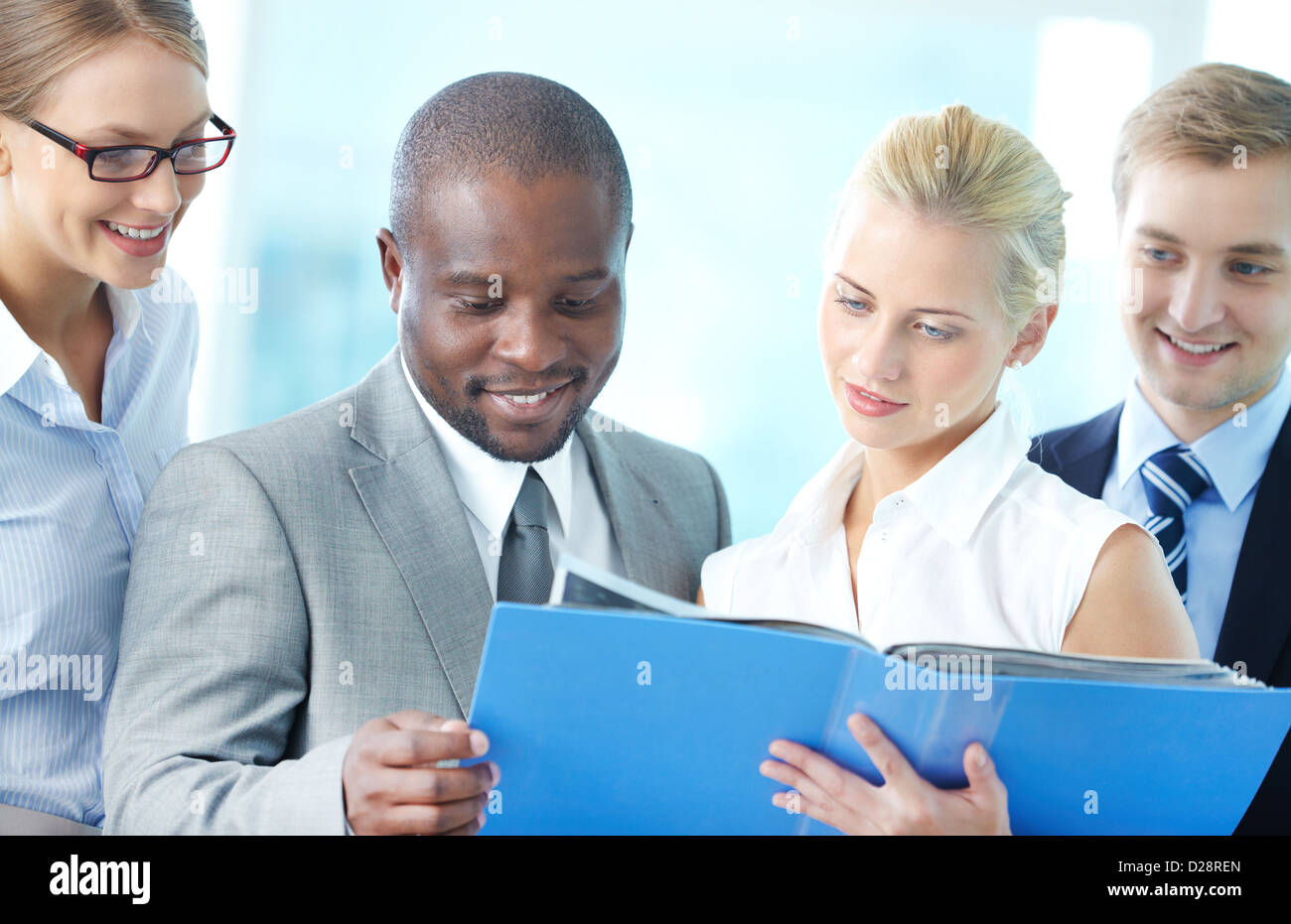 Portrait of confident employees looking at document at meeting Stock ...