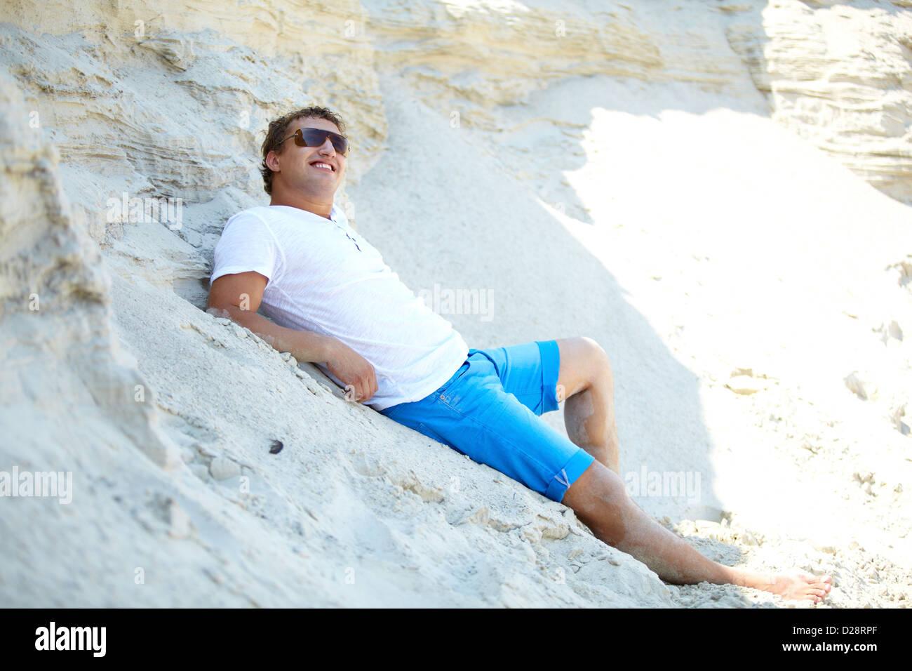 Young man relaxing on white sand of exotic beach Stock Photo - Alamy