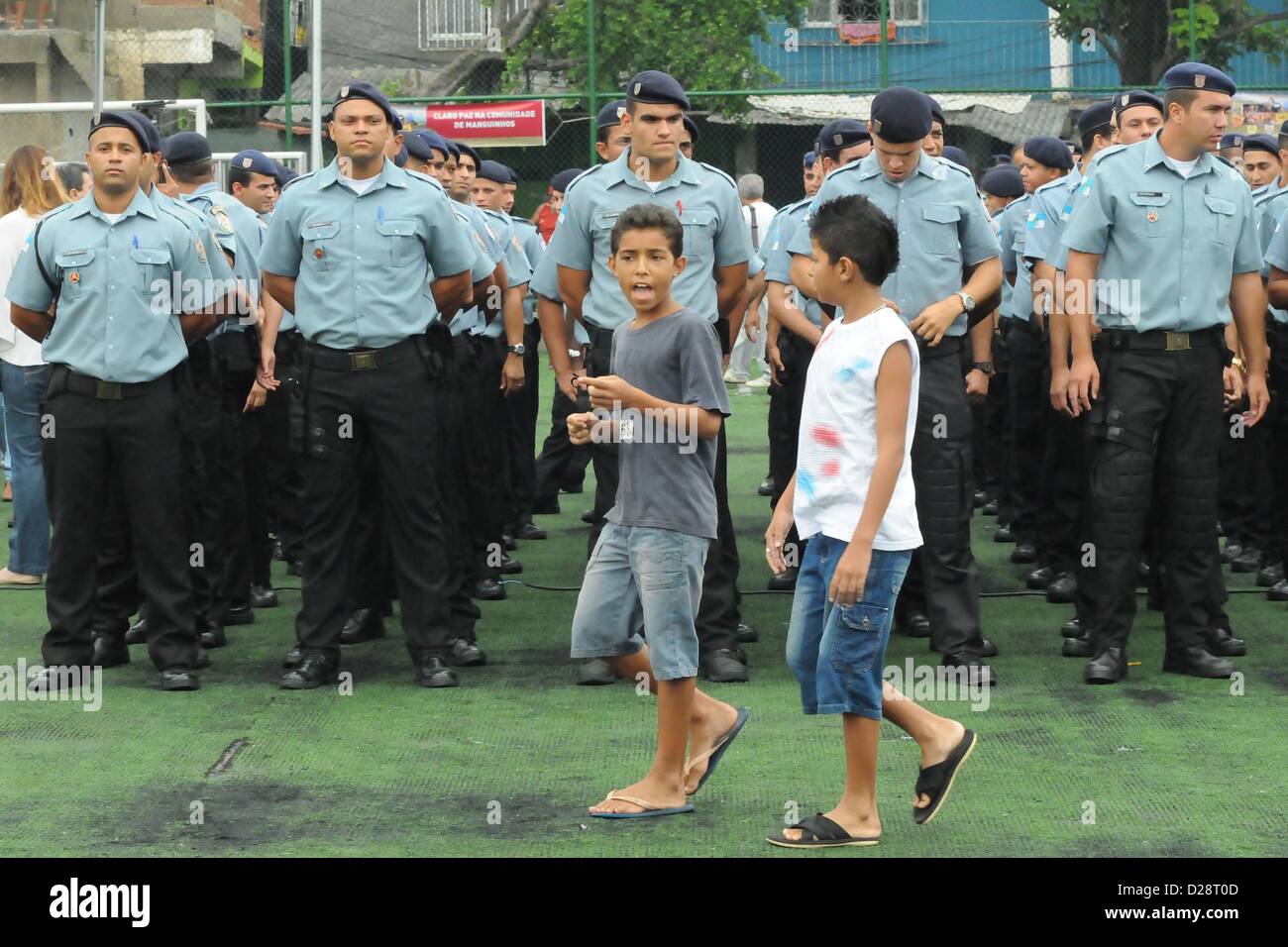 Rio de Janeiro, Brazil. 16th January 2013. Boys pass by policemen ...
