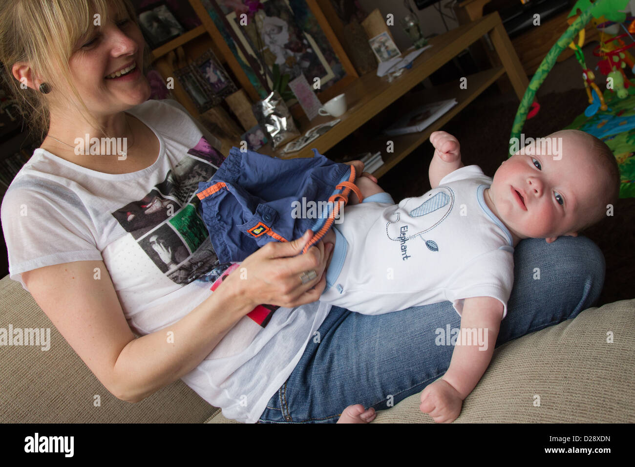 Mother dressing baby Stock Photo - Alamy