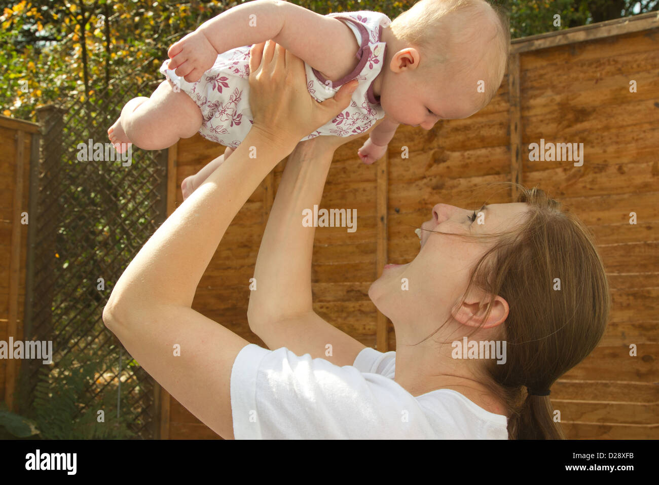 Mother lifting baby in the air Stock Photo - Alamy