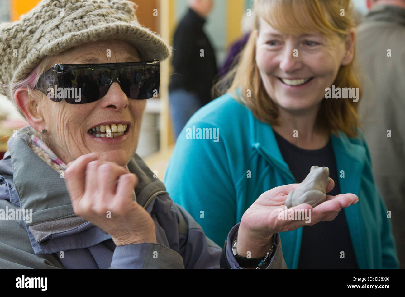 Visually impaired people with carers on outing to Denby Pottery. With ...