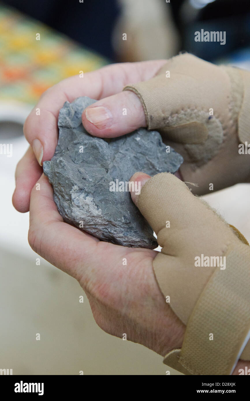 Visually impaired people with carers on outing to Denby Pottery. Hands ...