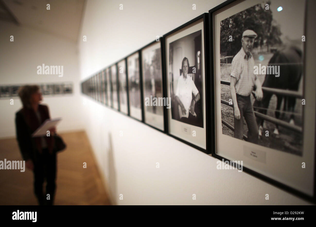 A woman views portaits from the series '100 Jahre' ('100 years') by Hans-Peter Feldmann at ...