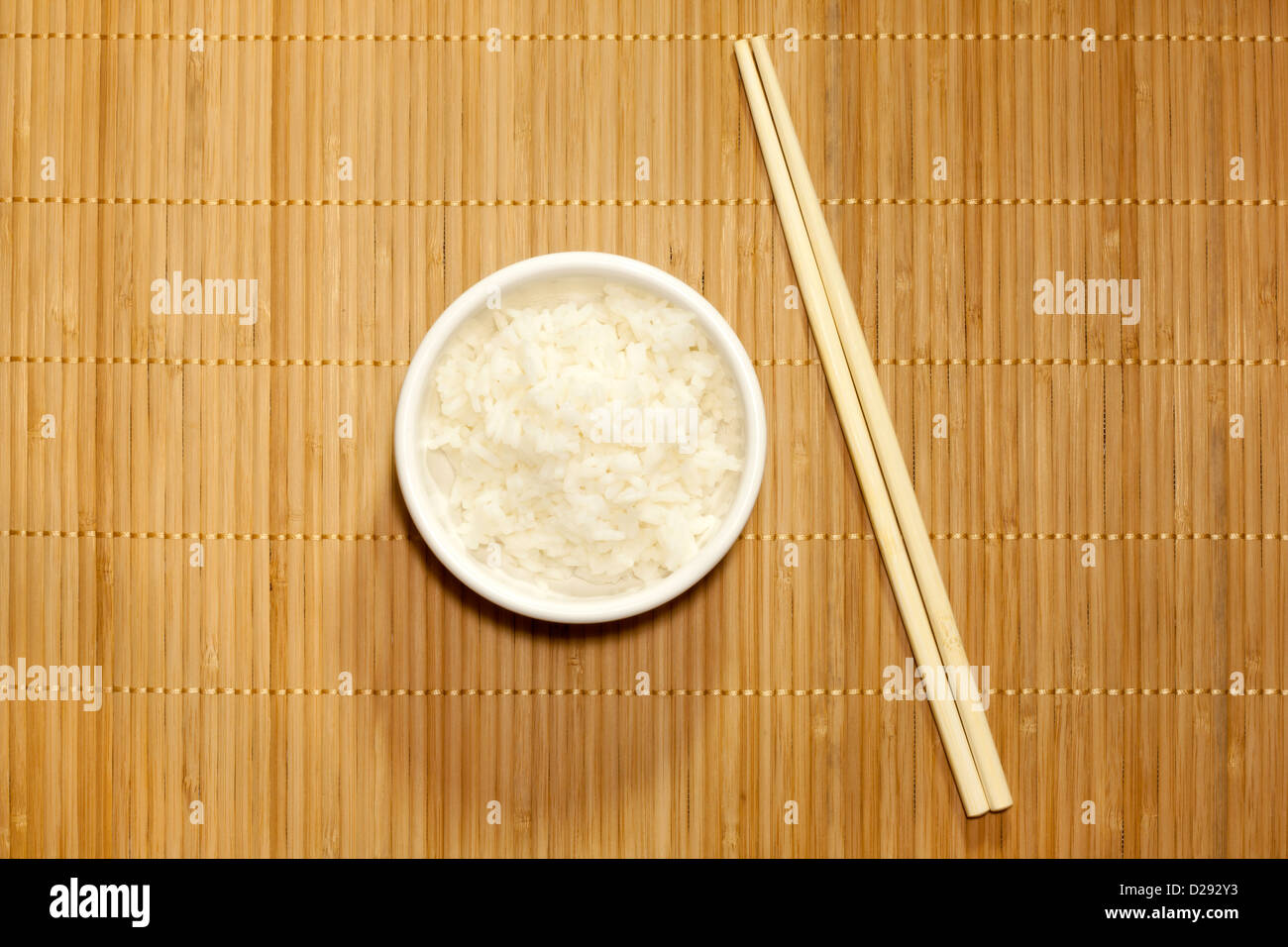 Rice on bamboo mat closeup with chopsticks Stock Photo - Alamy