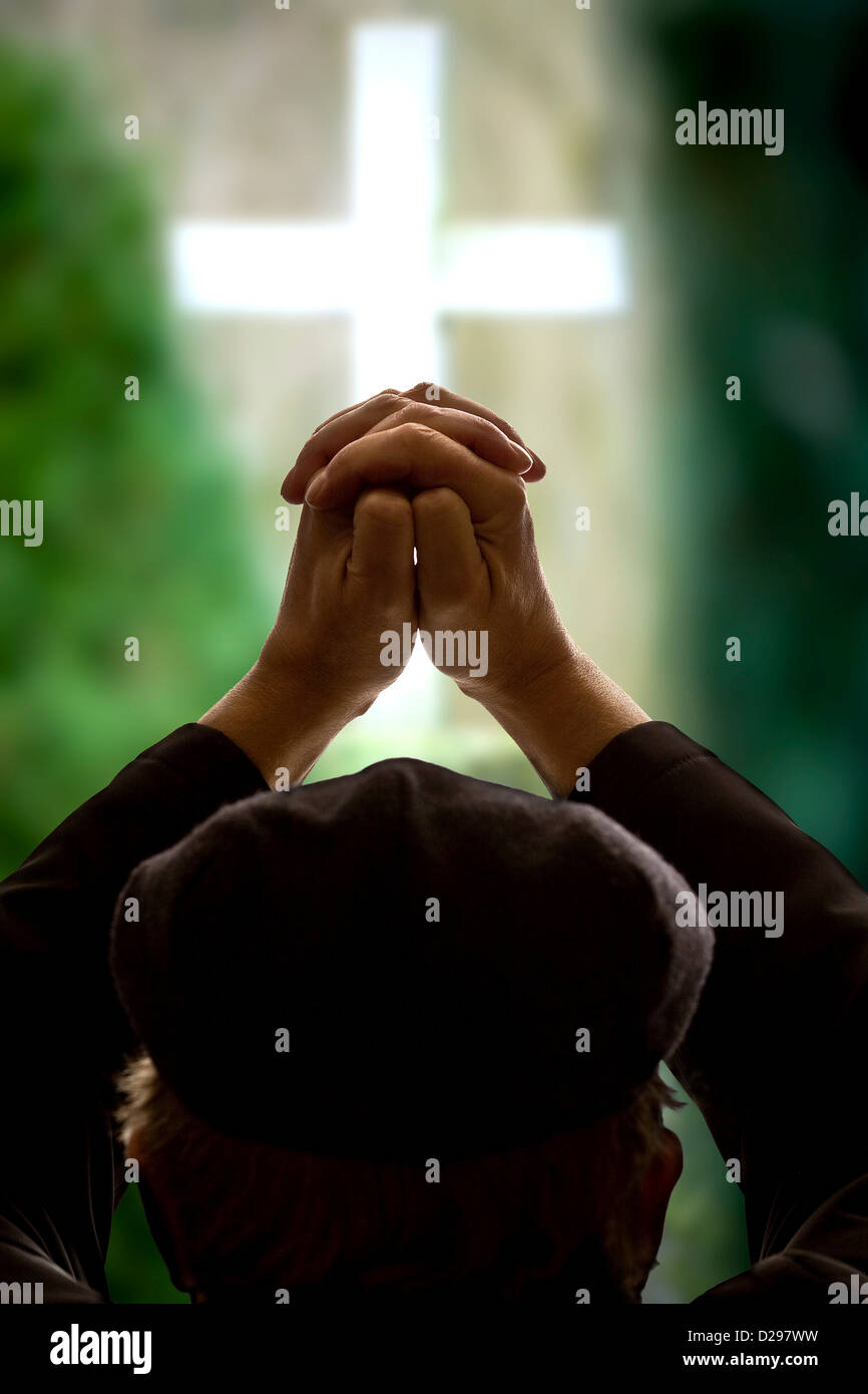 Man praying in front of cross Stock Photo - Alamy