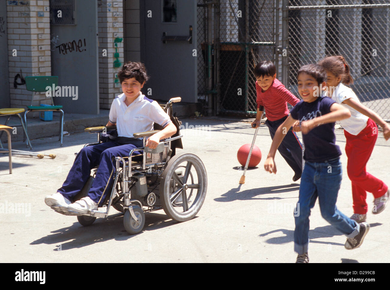 Physically Challenged Child In Wheelchair Playing With Other Children ...