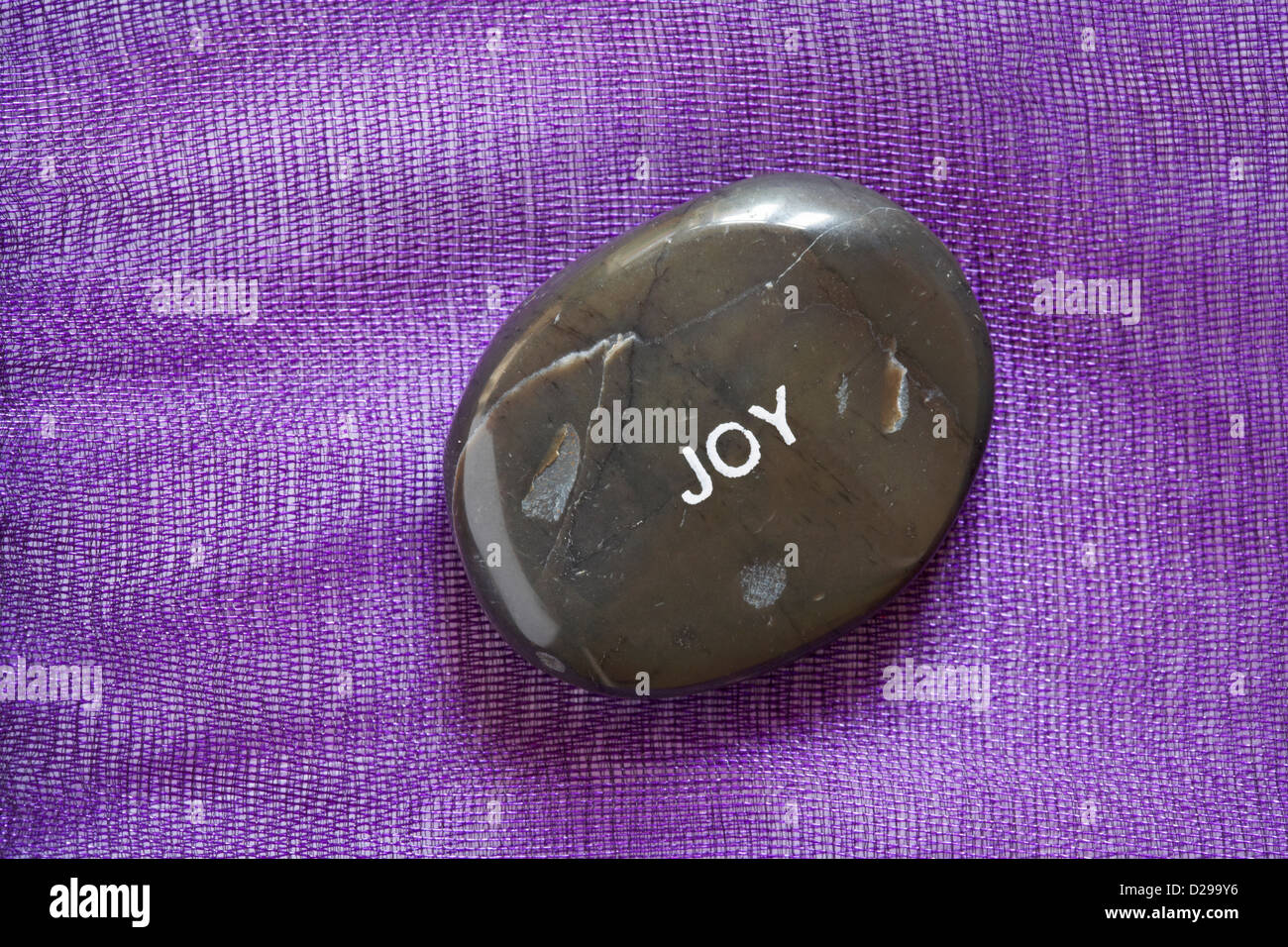 Fair Trade sentiment pebbles - Joy pebble isolated on purple background ...