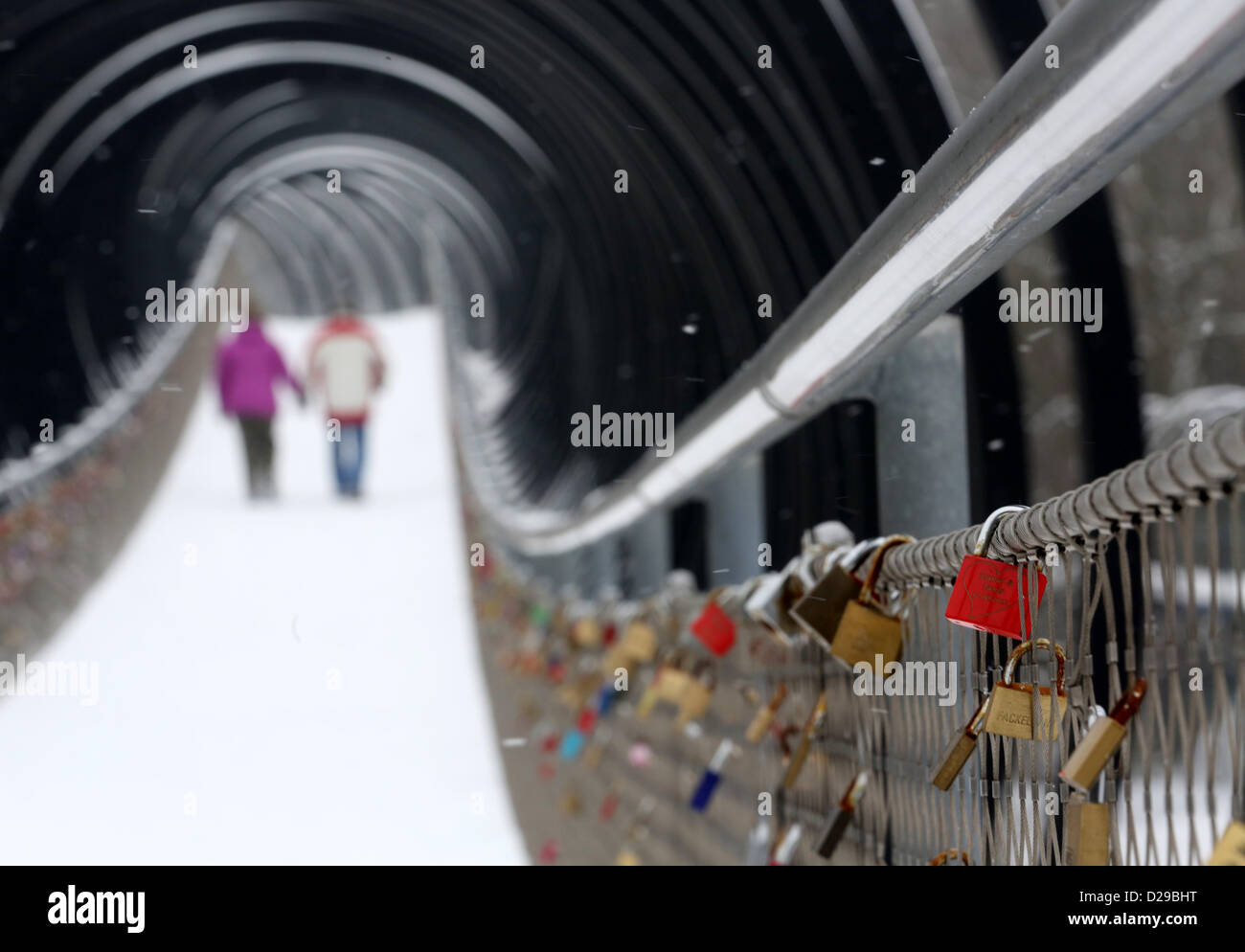 People walk across a snow-covered Slinky Springs Bridge in the ...