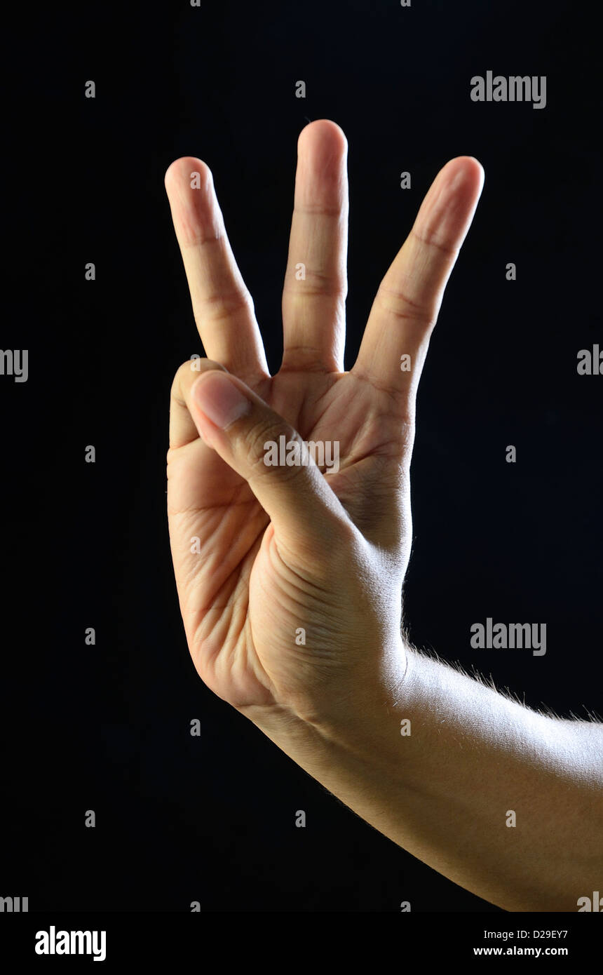 Hand showing three fingers on black background, closeup. Sign language ...