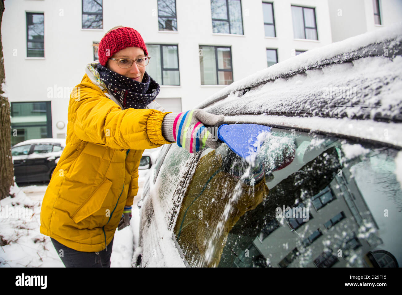 Woman cleans her car from ice and snow Stock Photo - Alamy