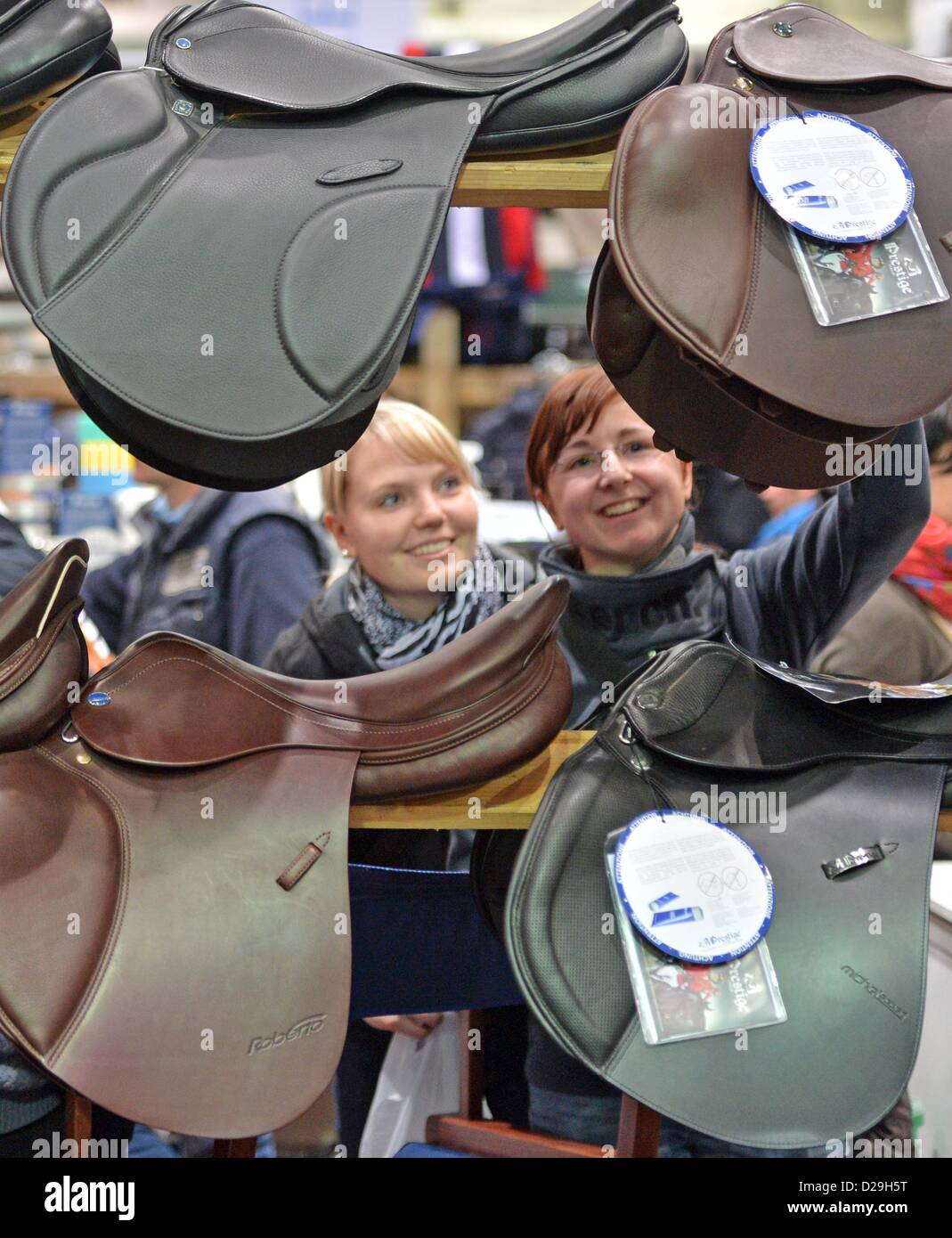 Visitors look at saddles at the Partner Pferd (horse) trade show in ...