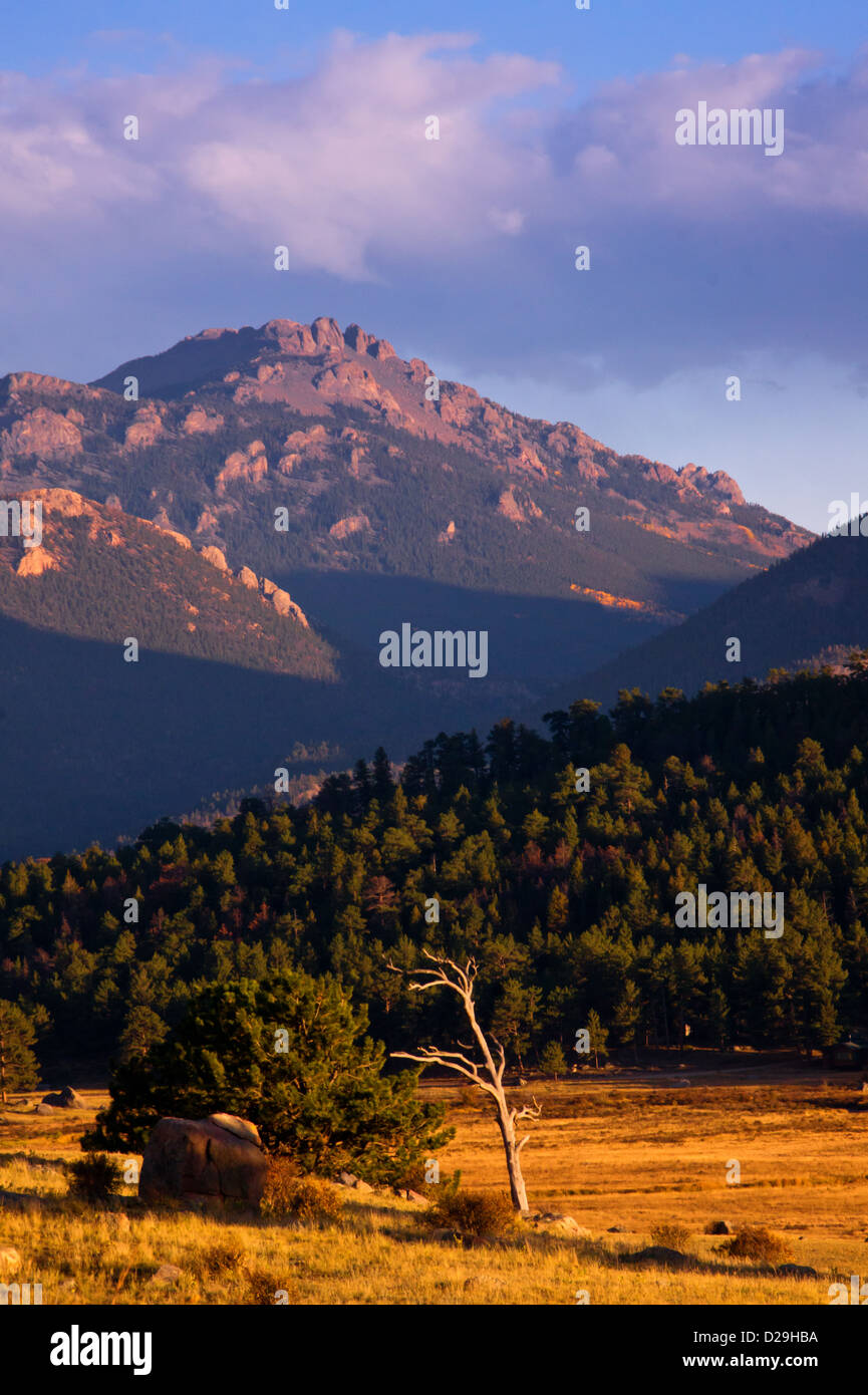 The color and sky of golden hour reflects against the mountainside of ...