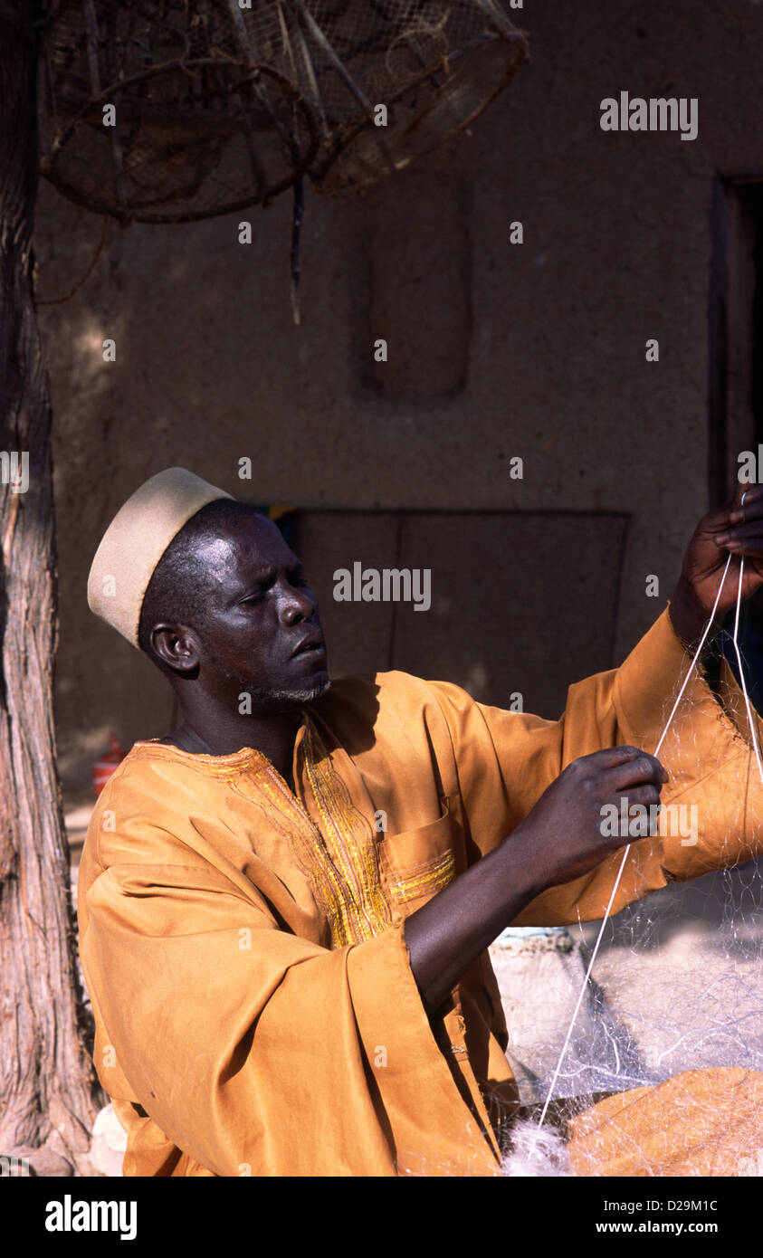 A Bozo fisherman preparing his nets in Mali, West Africa. Bozo are one ...
