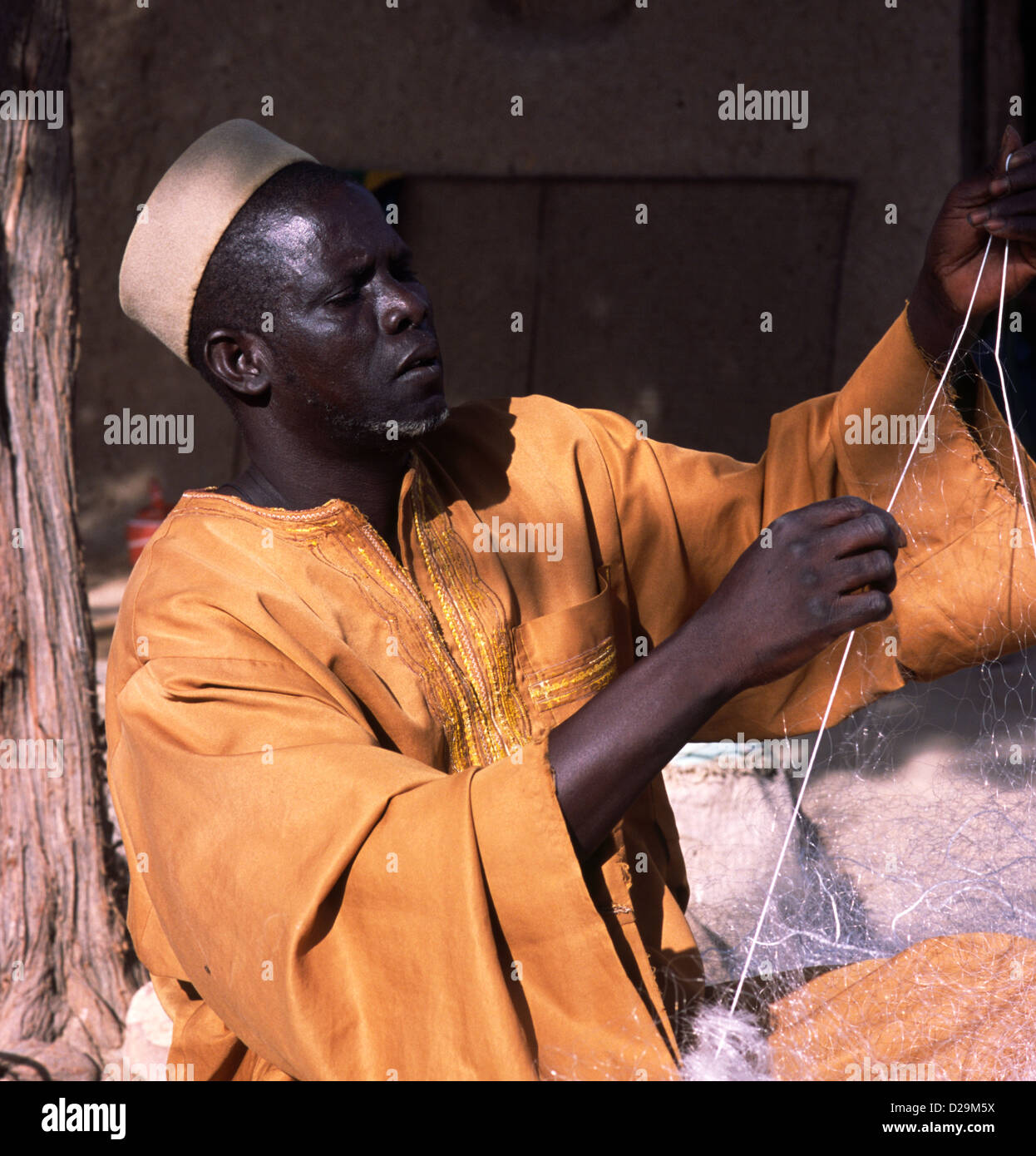 A Bozo fisherman preparing his nets in Mali, West Africa. Bozo are one ...