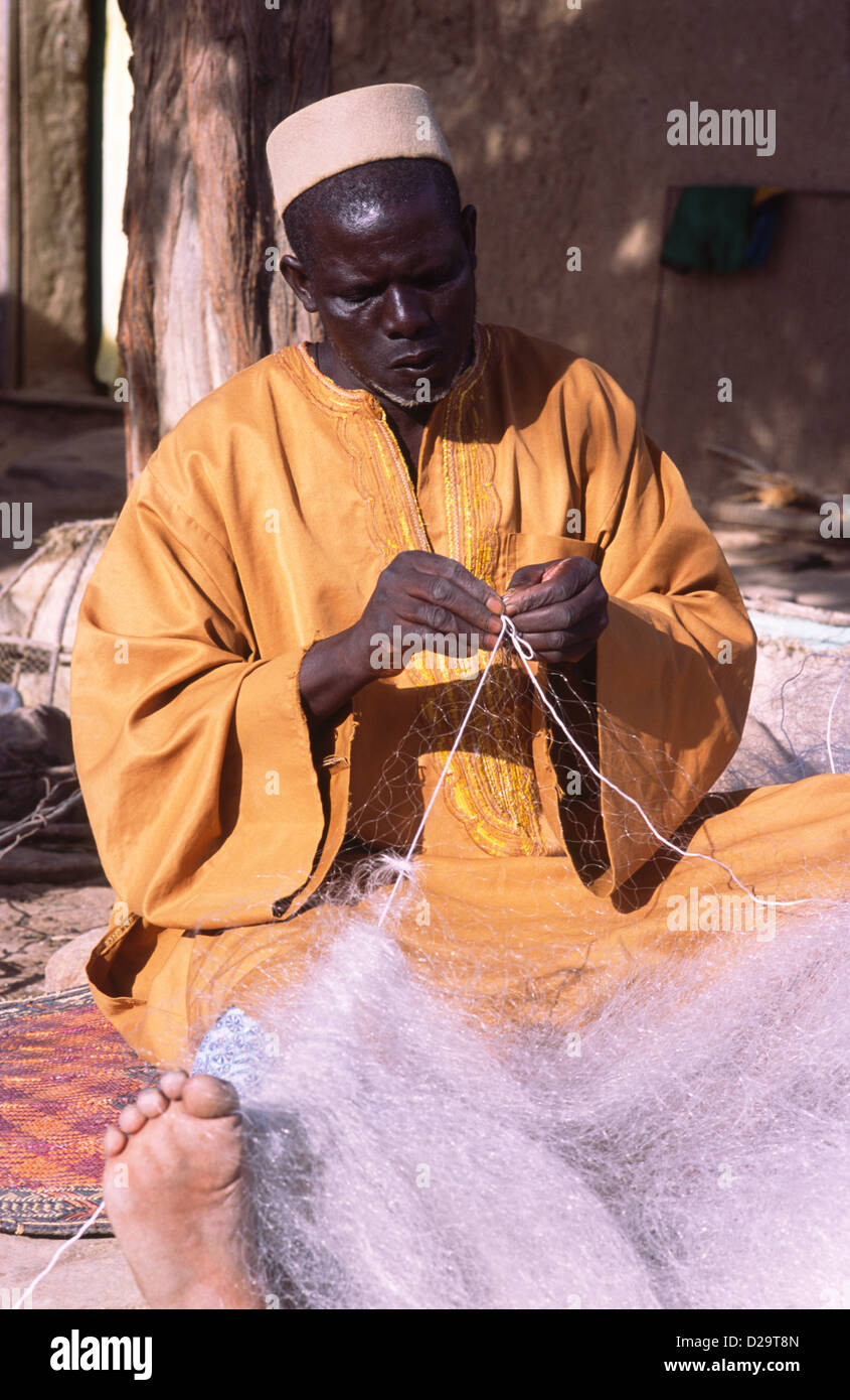 A Bozo fisherman preparing his nets in Mali, West Africa. Bozo are one ...