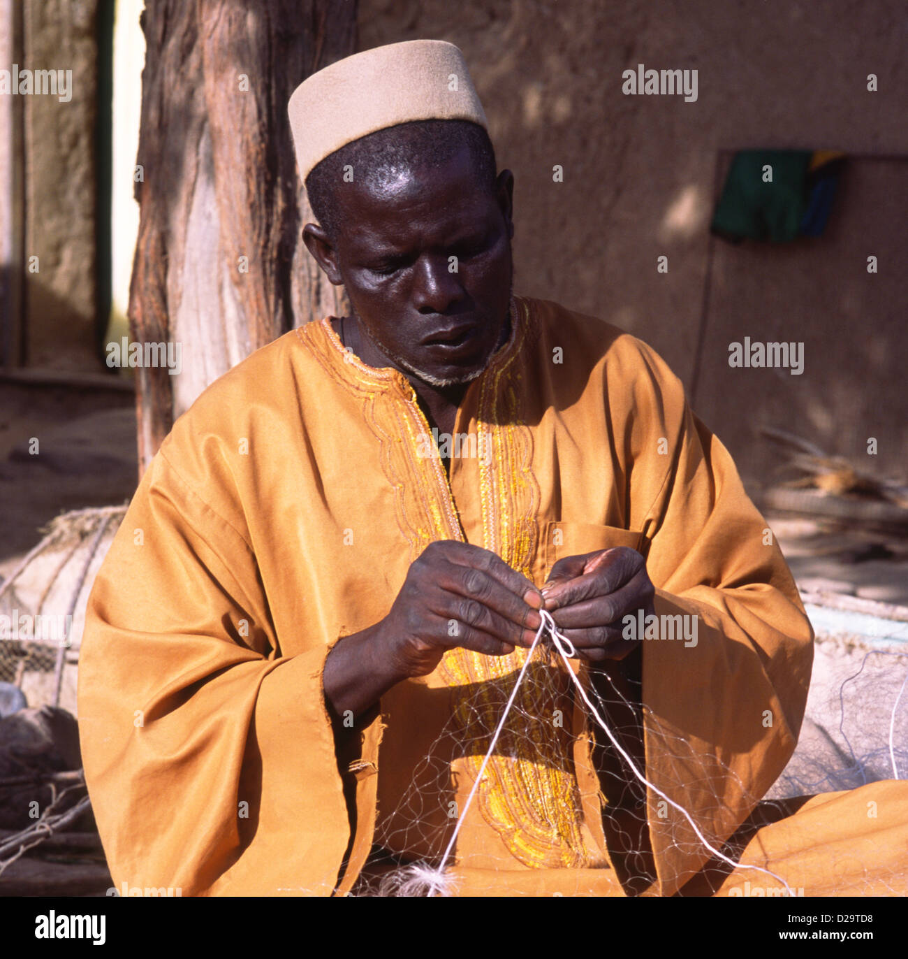 A Bozo fisherman preparing his nets in Mali, West Africa. Bozo are one ...