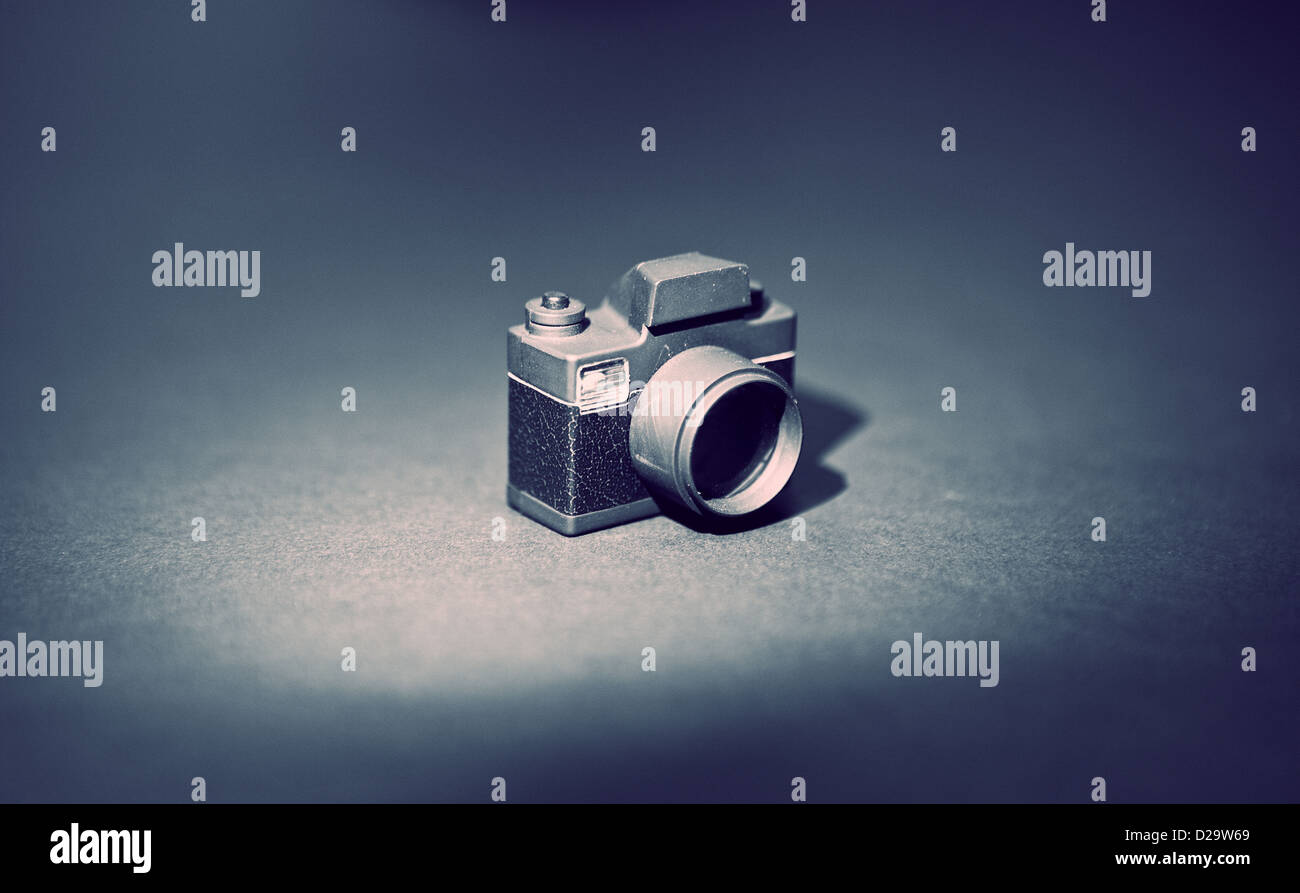 A still life image of a miniature DSLR captured under the spotlight ...