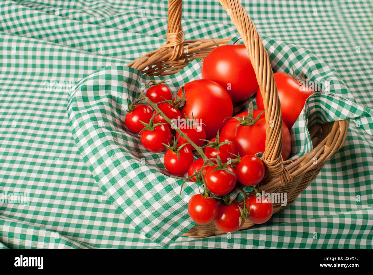 Cherry tomatoes and their big cousins together in a rustic basket Stock ...
