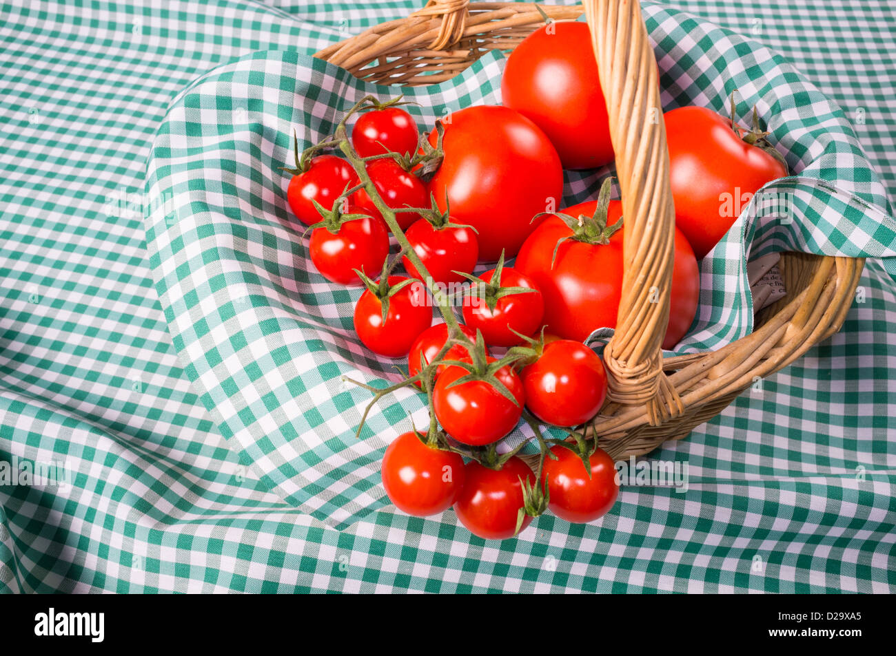 Cherry tomatoes and their big cousins together in a rustic basket Stock ...