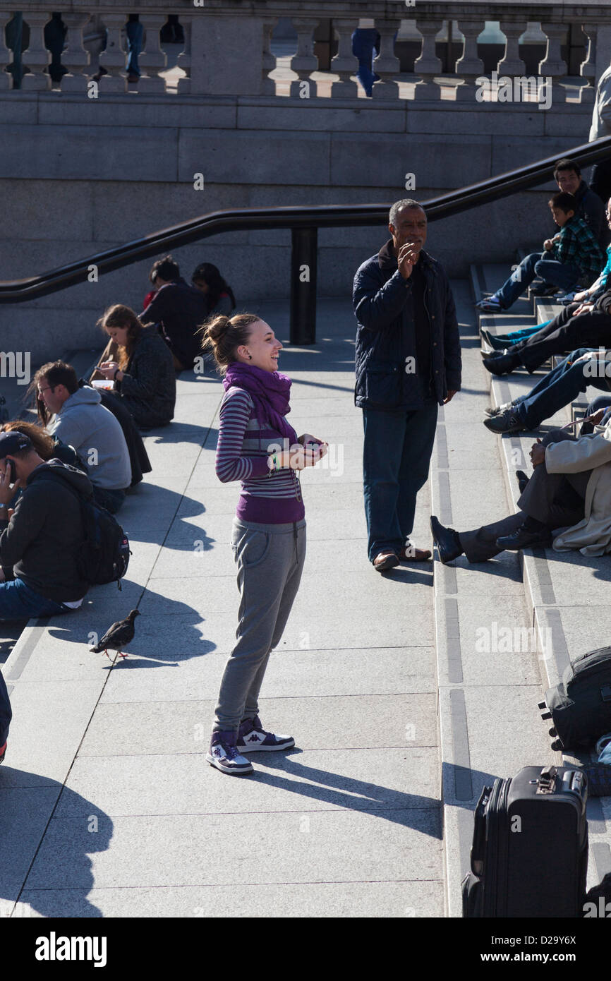 Woman tourist laughs as she prepares to photograph her friends in ...
