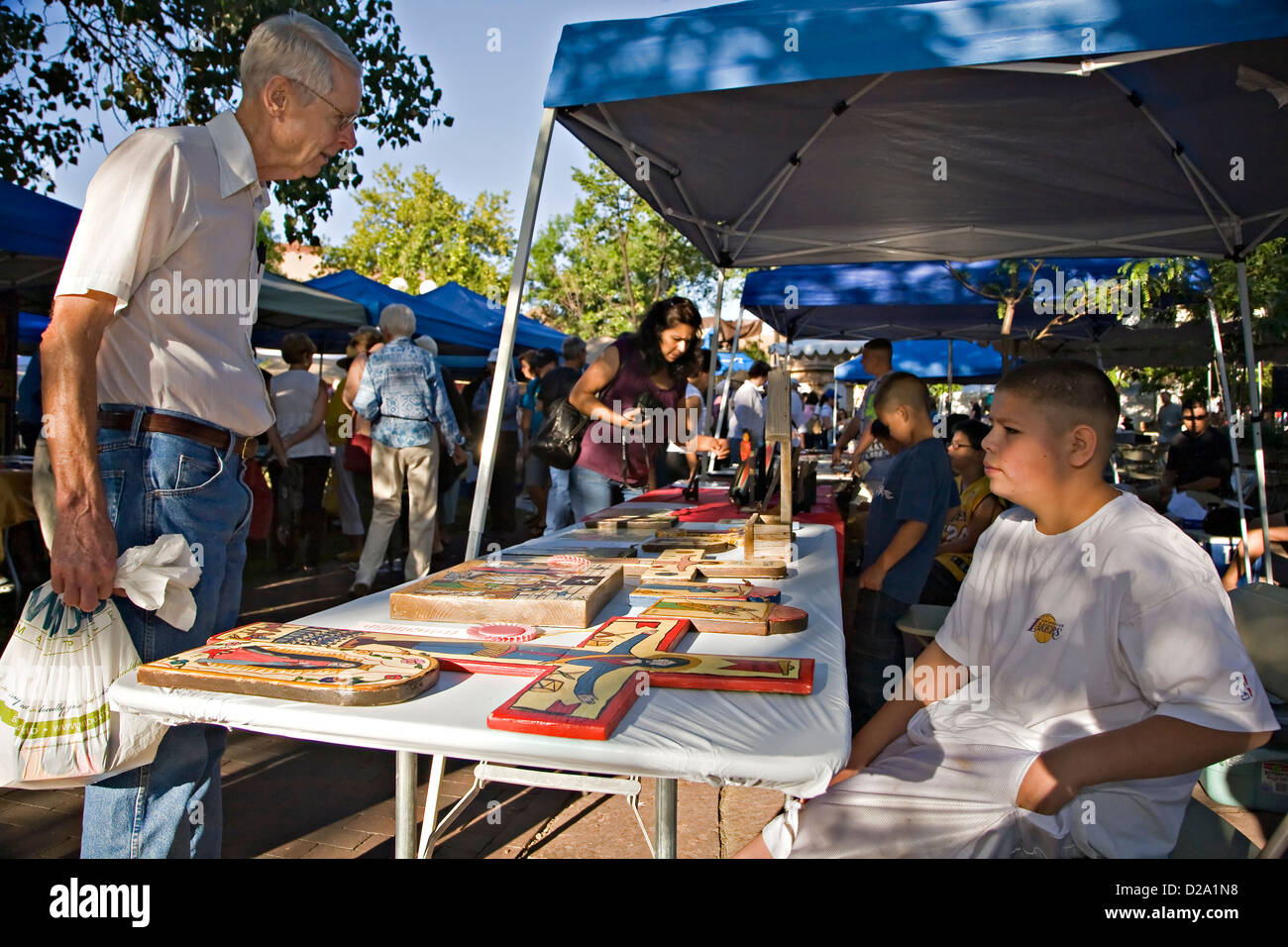 Tourist views youth artist Chris Tapia's display of hand painted ...