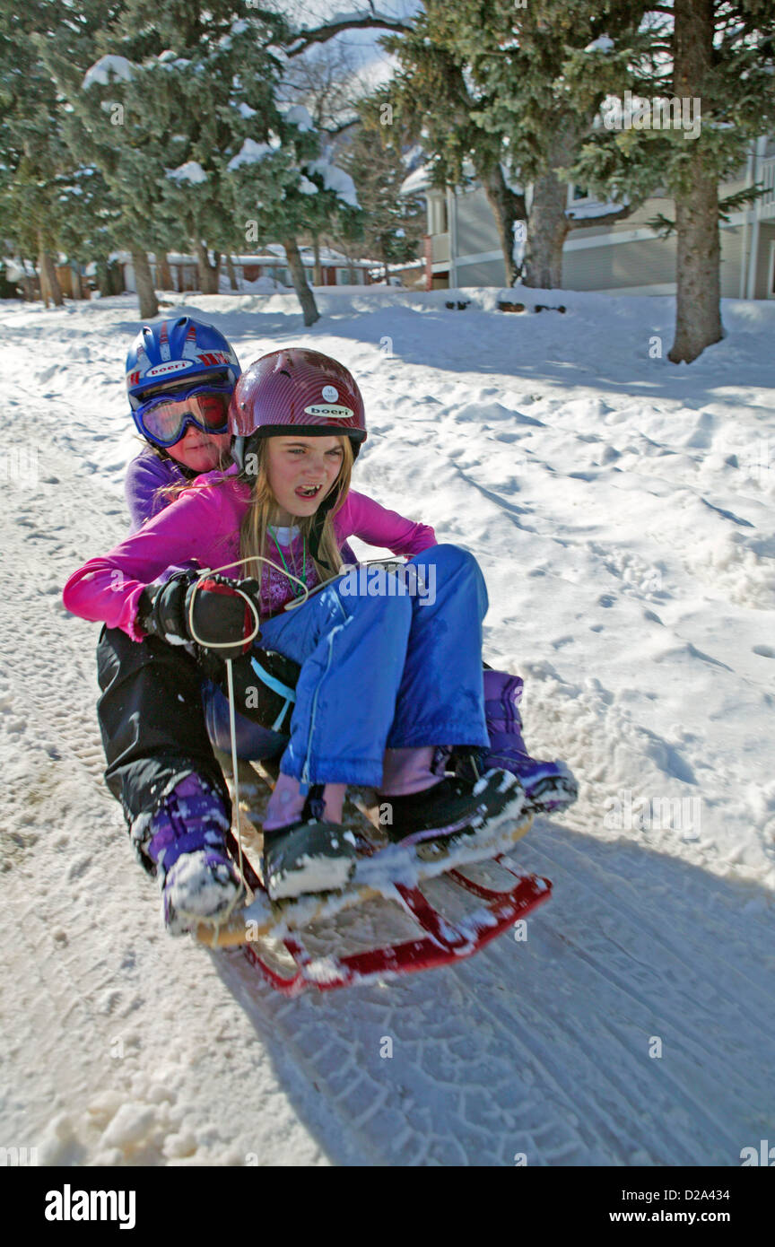 Two girls riding sled city street hi-res stock photography and images ...