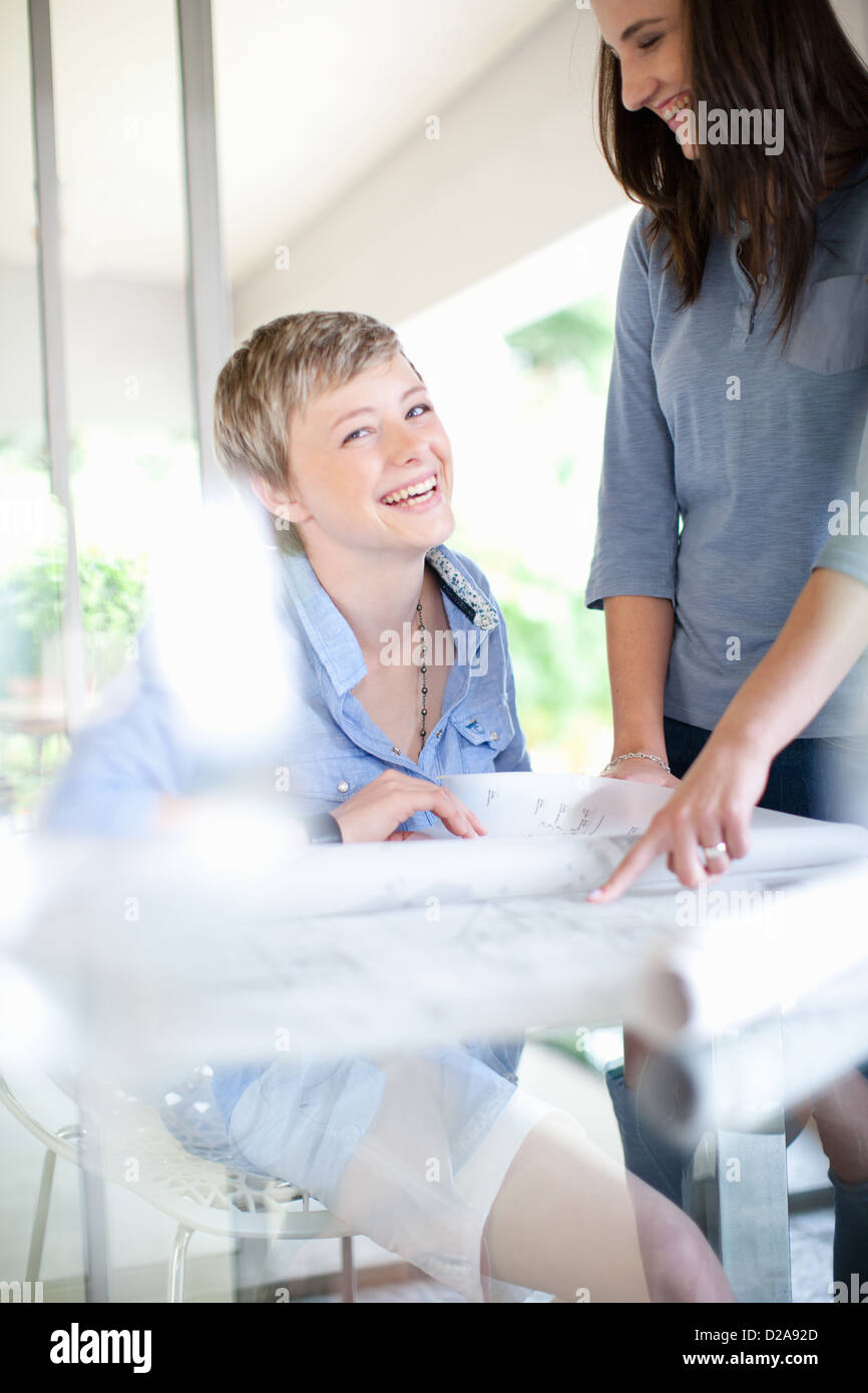 Women reading blueprints together Stock Photo - Alamy