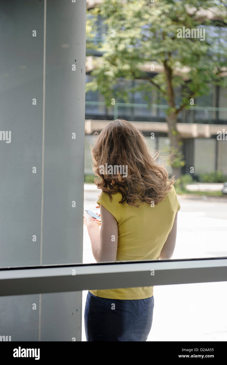 Woman leaning against window Stock Photo - Alamy