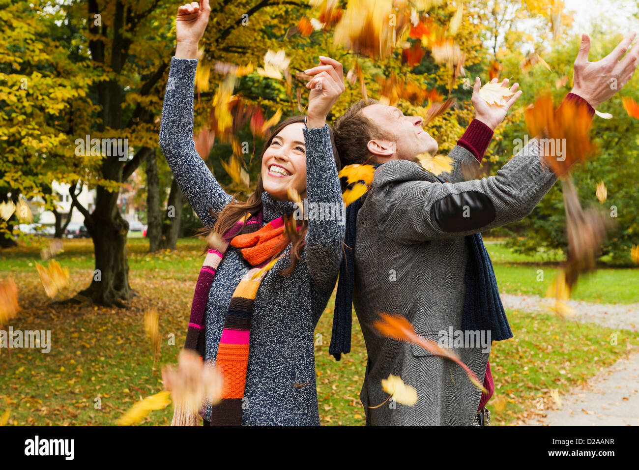 Woman standing throwing autumnal leaves hi-res stock photography and ...