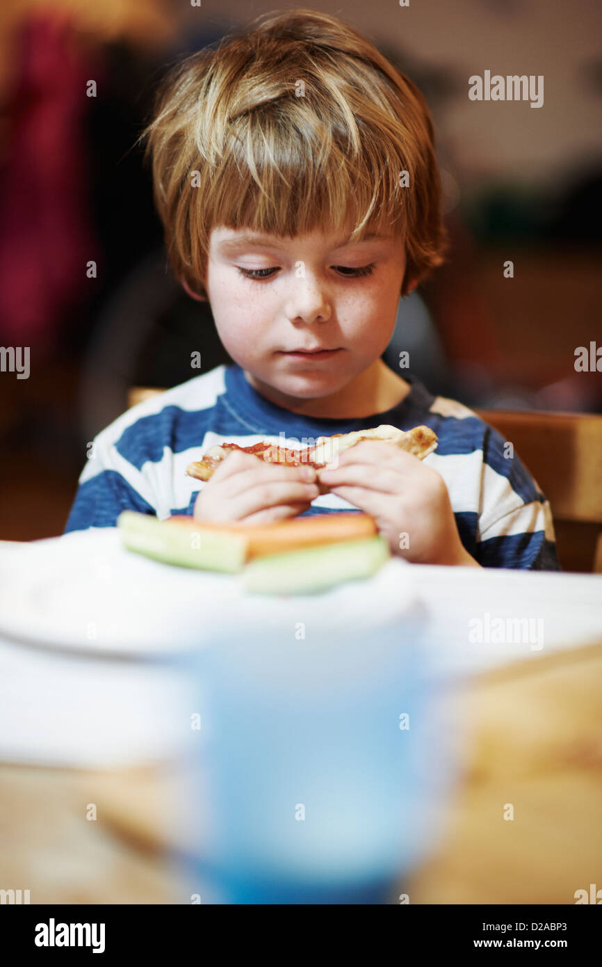 Boy eating at table Stock Photo - Alamy