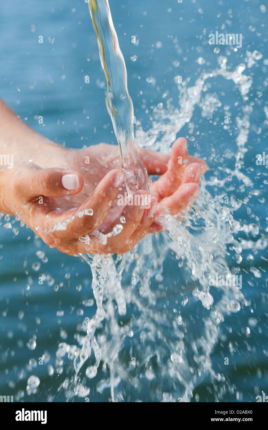 Woman catching water stream in hands Stock Photo - Alamy