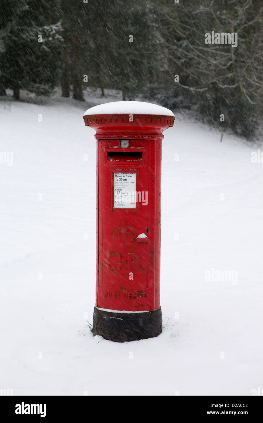 Royal Mail traditional red post box standing in the snow, with snow ...