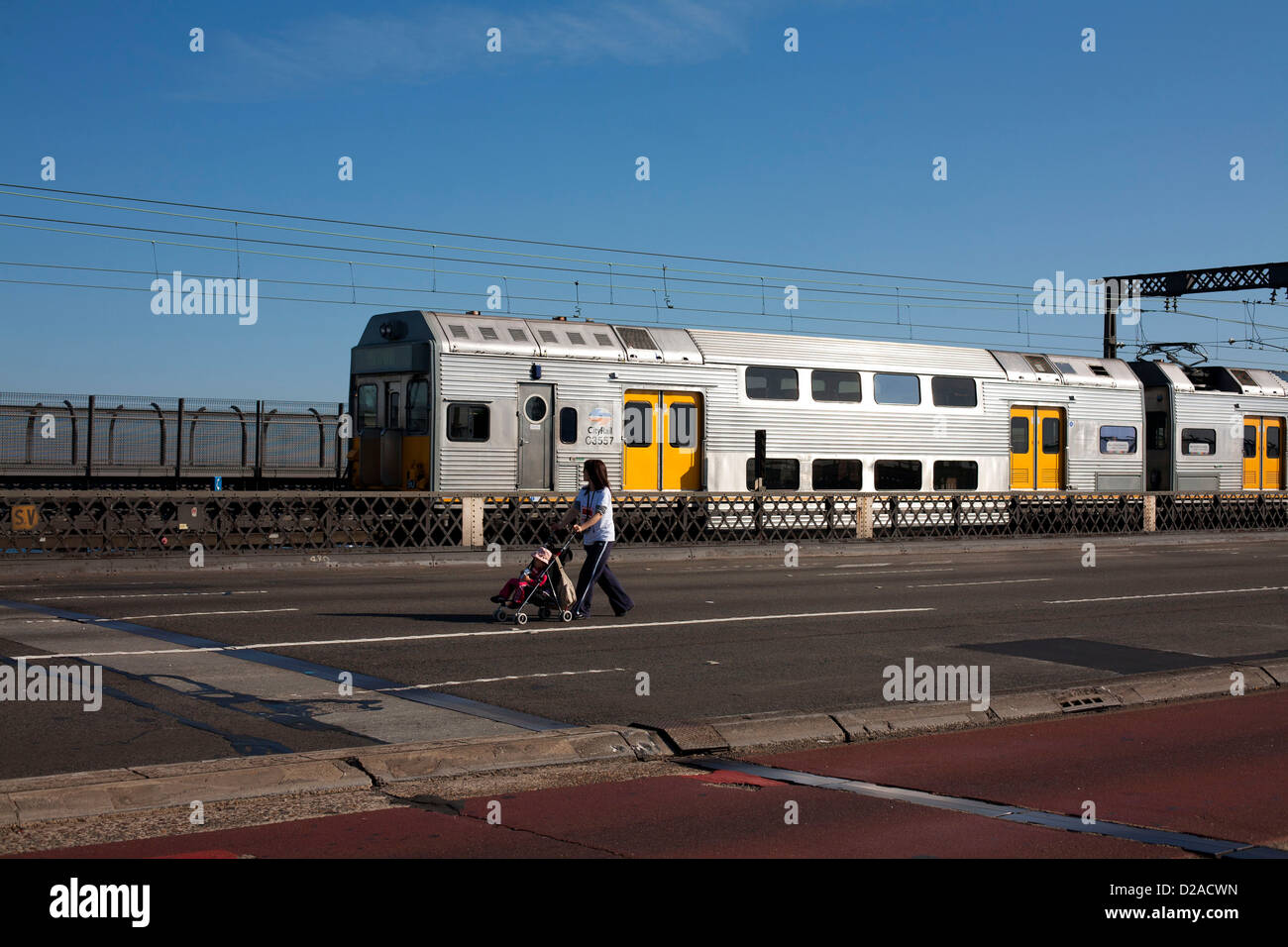 A lady with pram walking across the deserted Sydney Harbour Bridge with ...