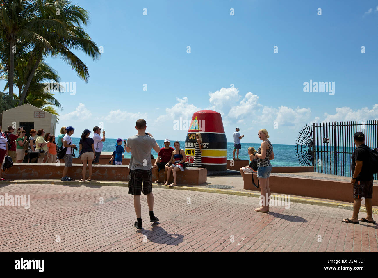 Tourists taking pictures at the Southernmost Point buoy in Key West ...