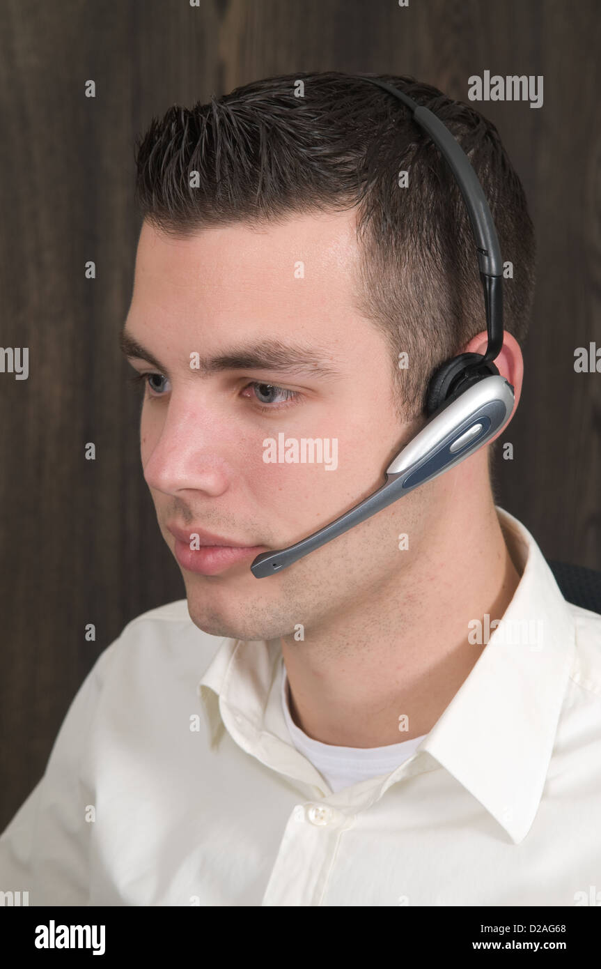 Male receptionist working at a helpdesk in an office Stock Photo - Alamy