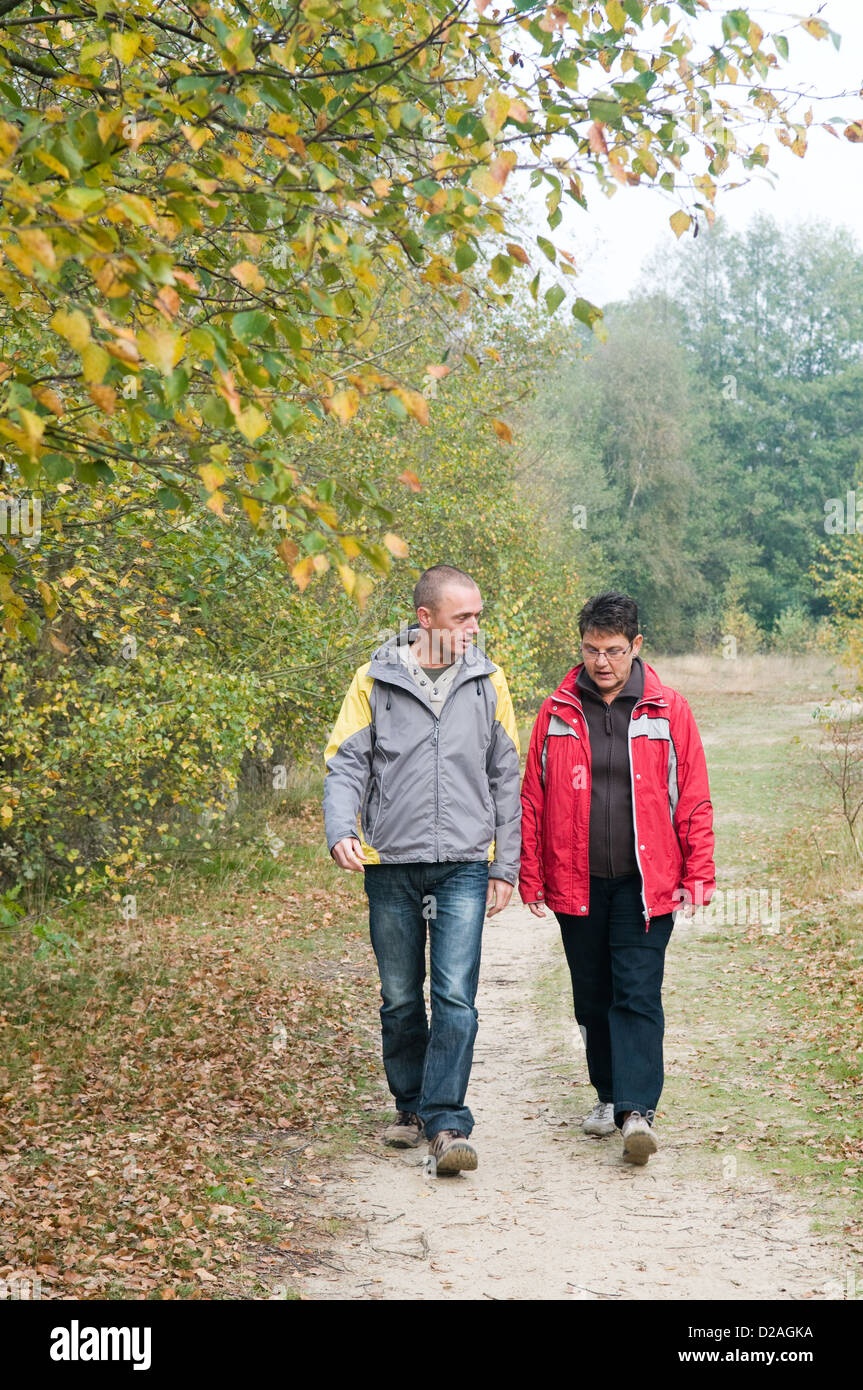 Man and a woman having a walk in the forest Stock Photo - Alamy
