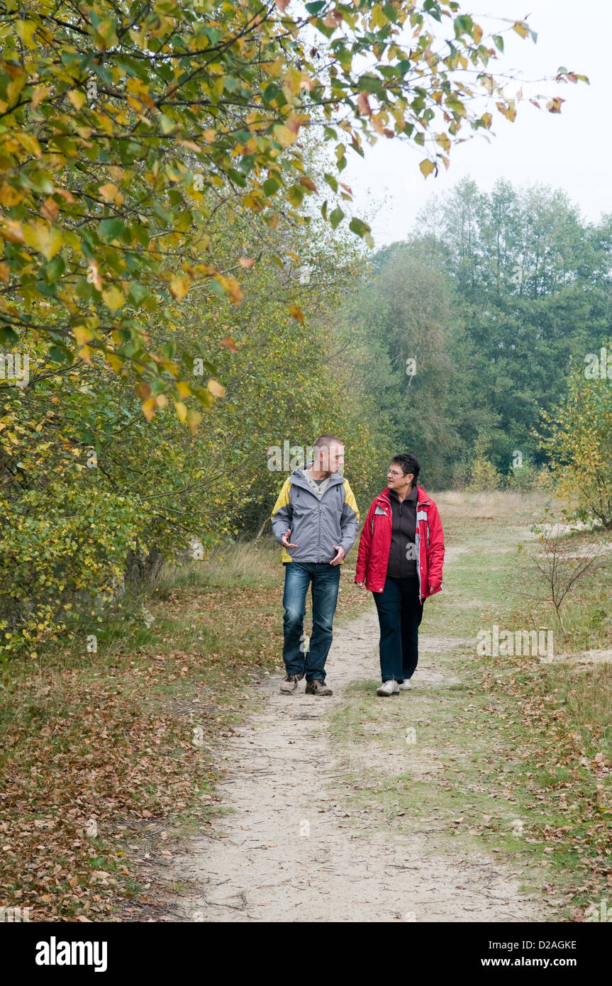 Man and a woman having a walk in the forest Stock Photo - Alamy