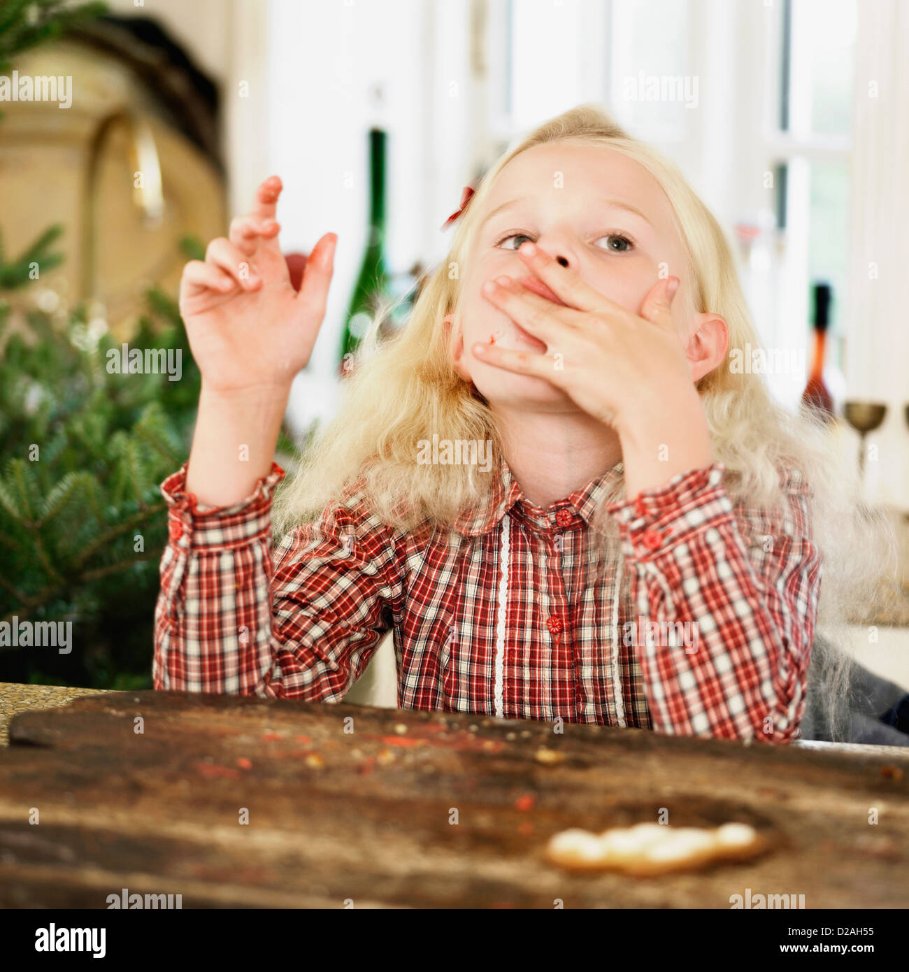 Girl eating Christmas cookies in kitchen Stock Photo - Alamy