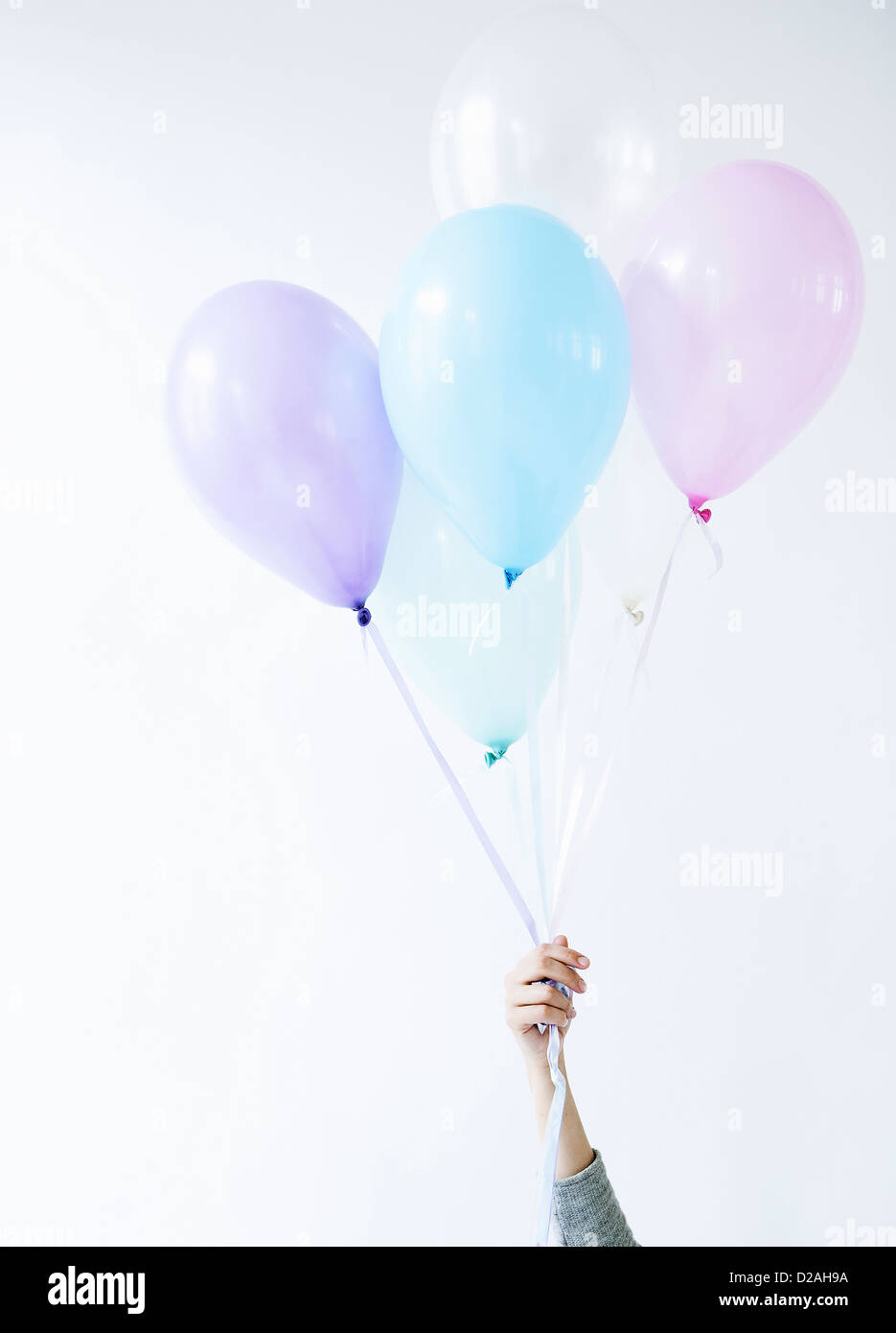 Hand holding bunch of balloons Stock Photo - Alamy