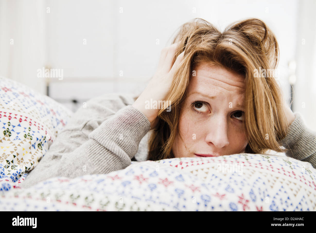 Woman ruffling her hair on bed Stock Photo - Alamy