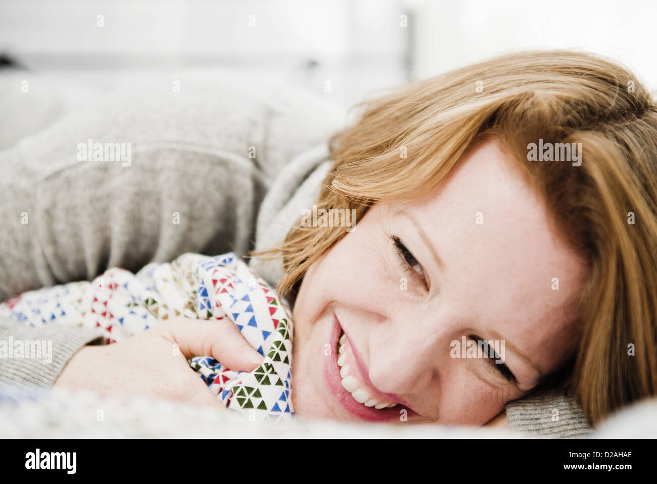 Smiling woman laying on bed Stock Photo - Alamy