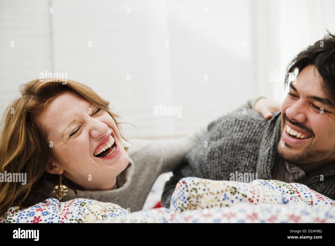 Couple laughing together on bed Stock Photo - Alamy