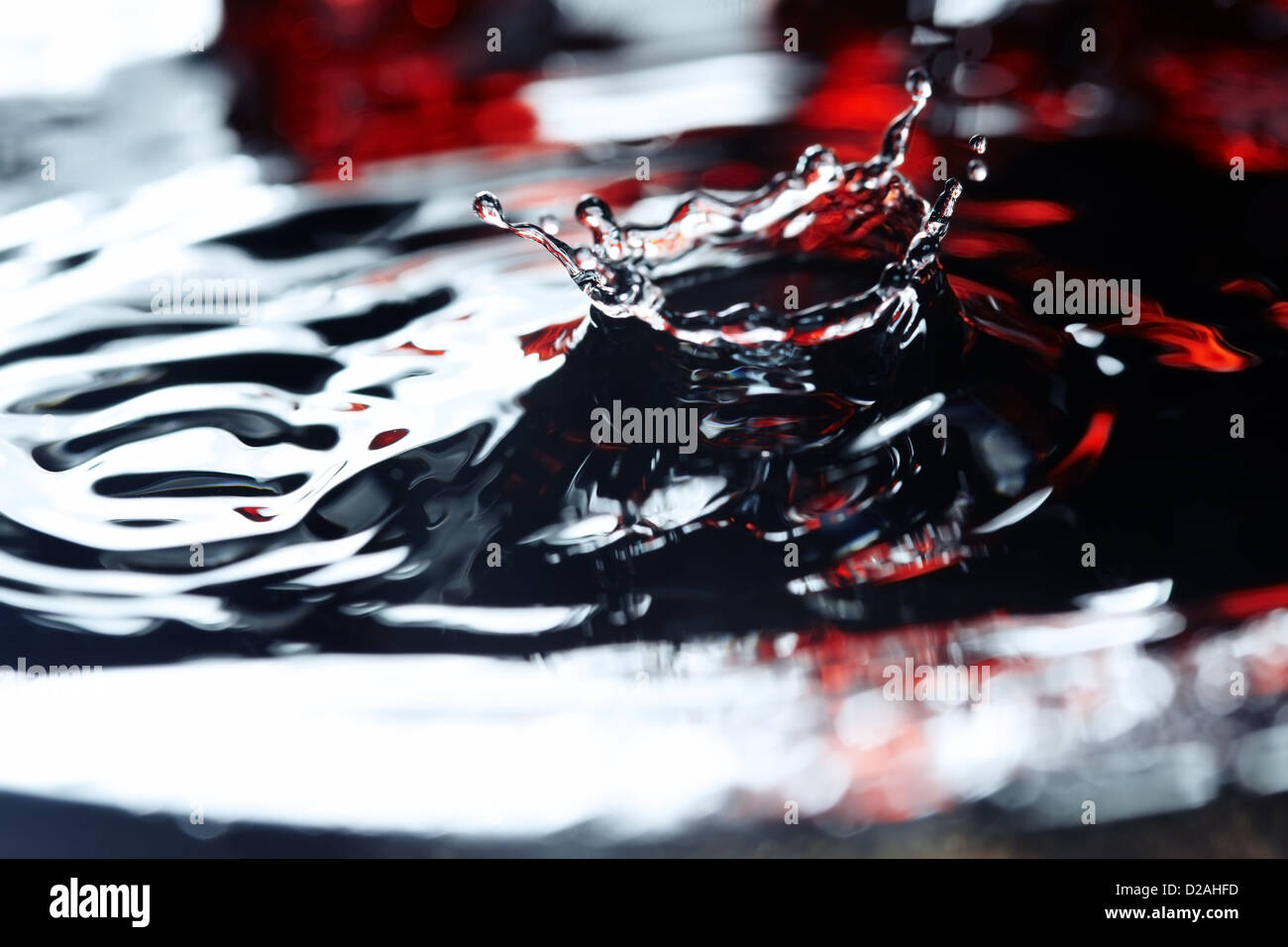 Extremely macro photo of the liquid drop falling on a wet colorful ...