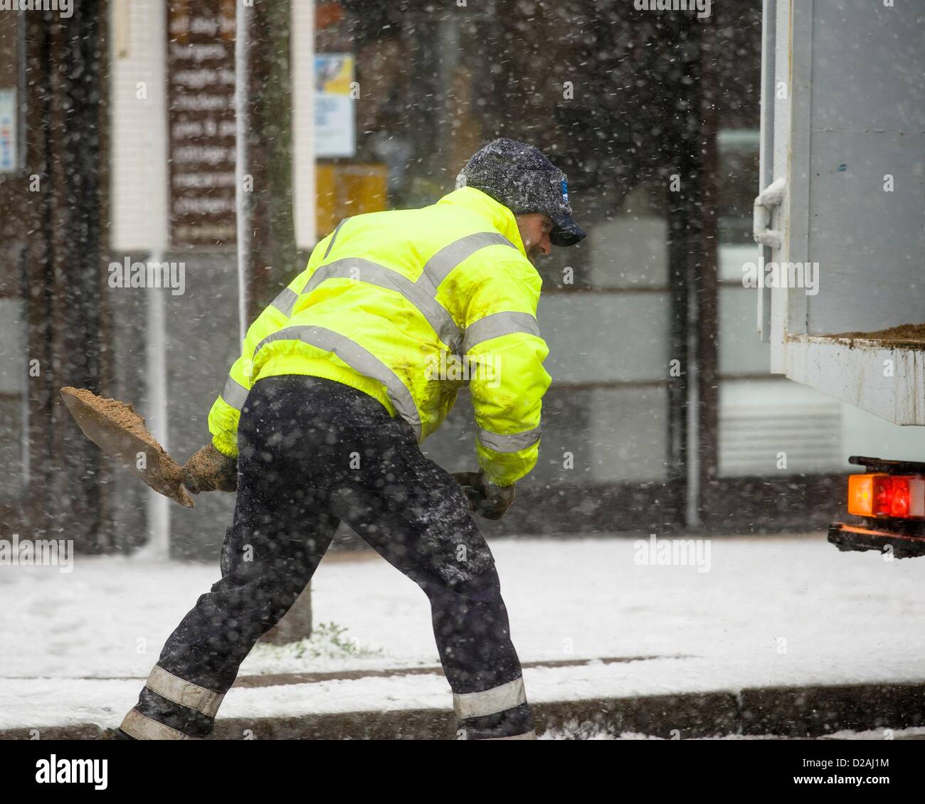 Manual road gritting in front of a seafront coffee shop and ice cream ...