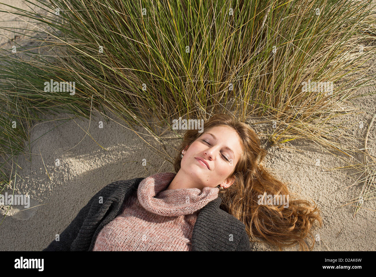 Woman napping on beach Stock Photo - Alamy